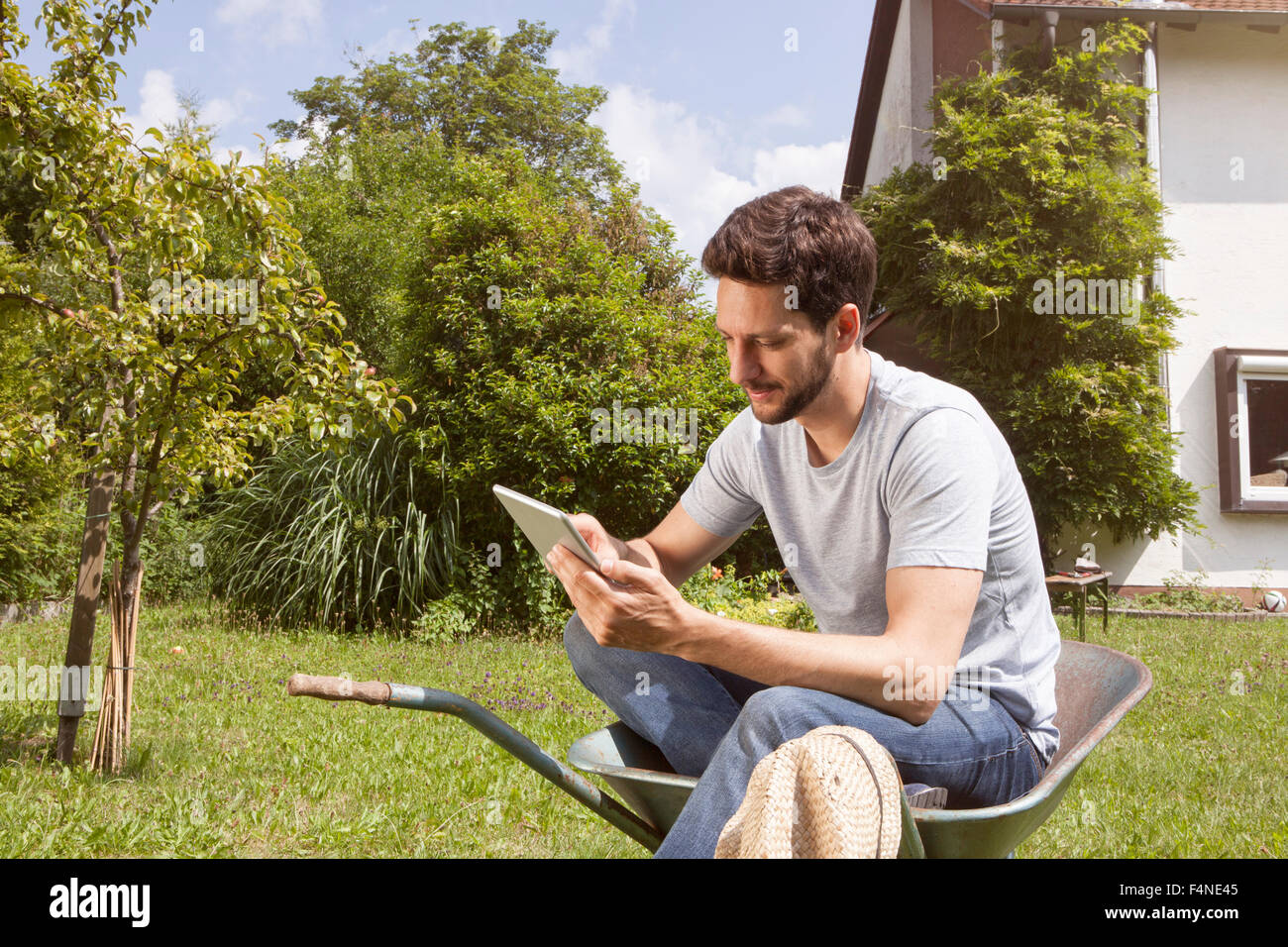 Man using wheelbarrow hi-res stock photography and images - Alamy