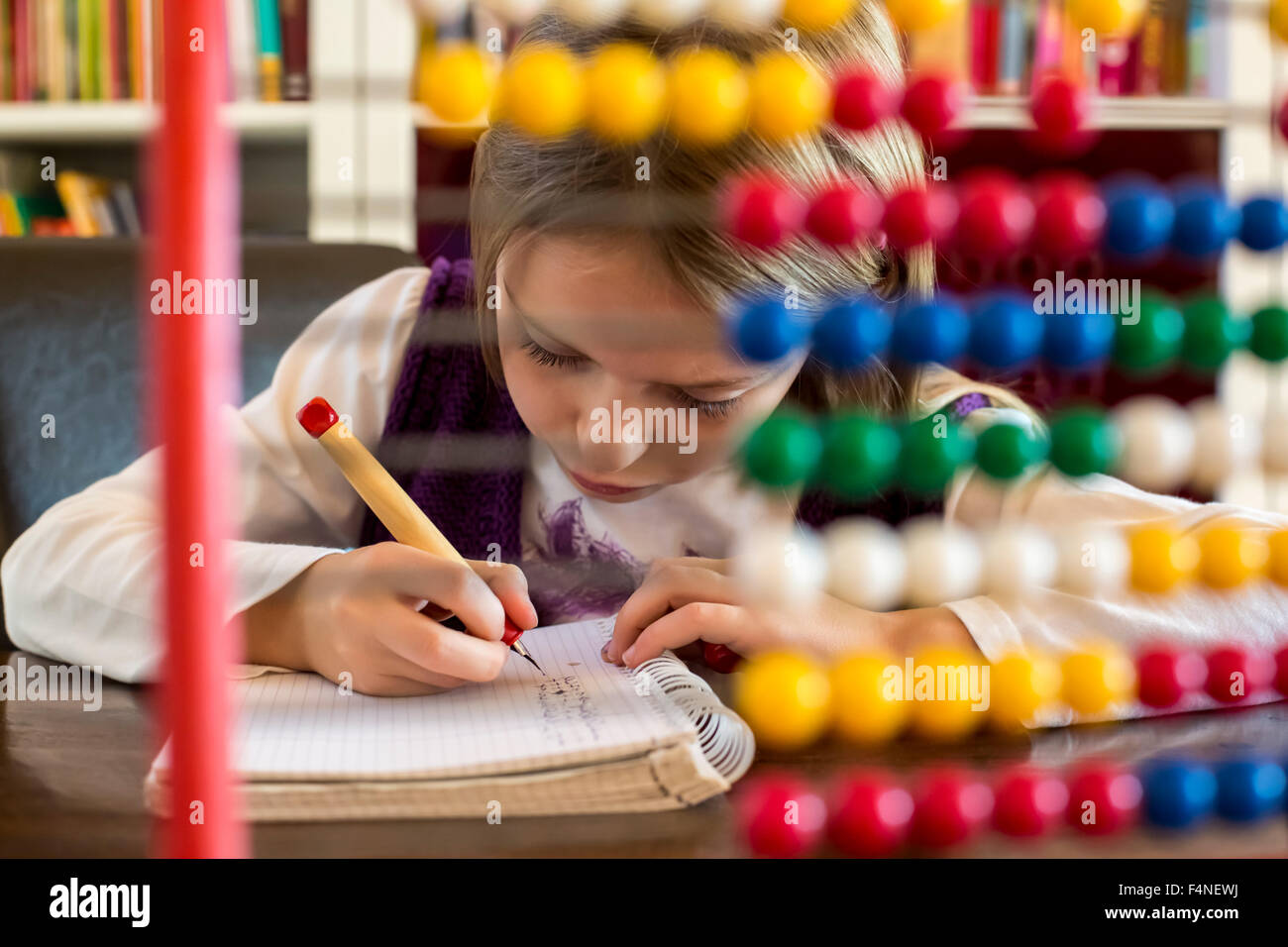 Girl sitting behind abacus doing homework Stock Photo - Alamy