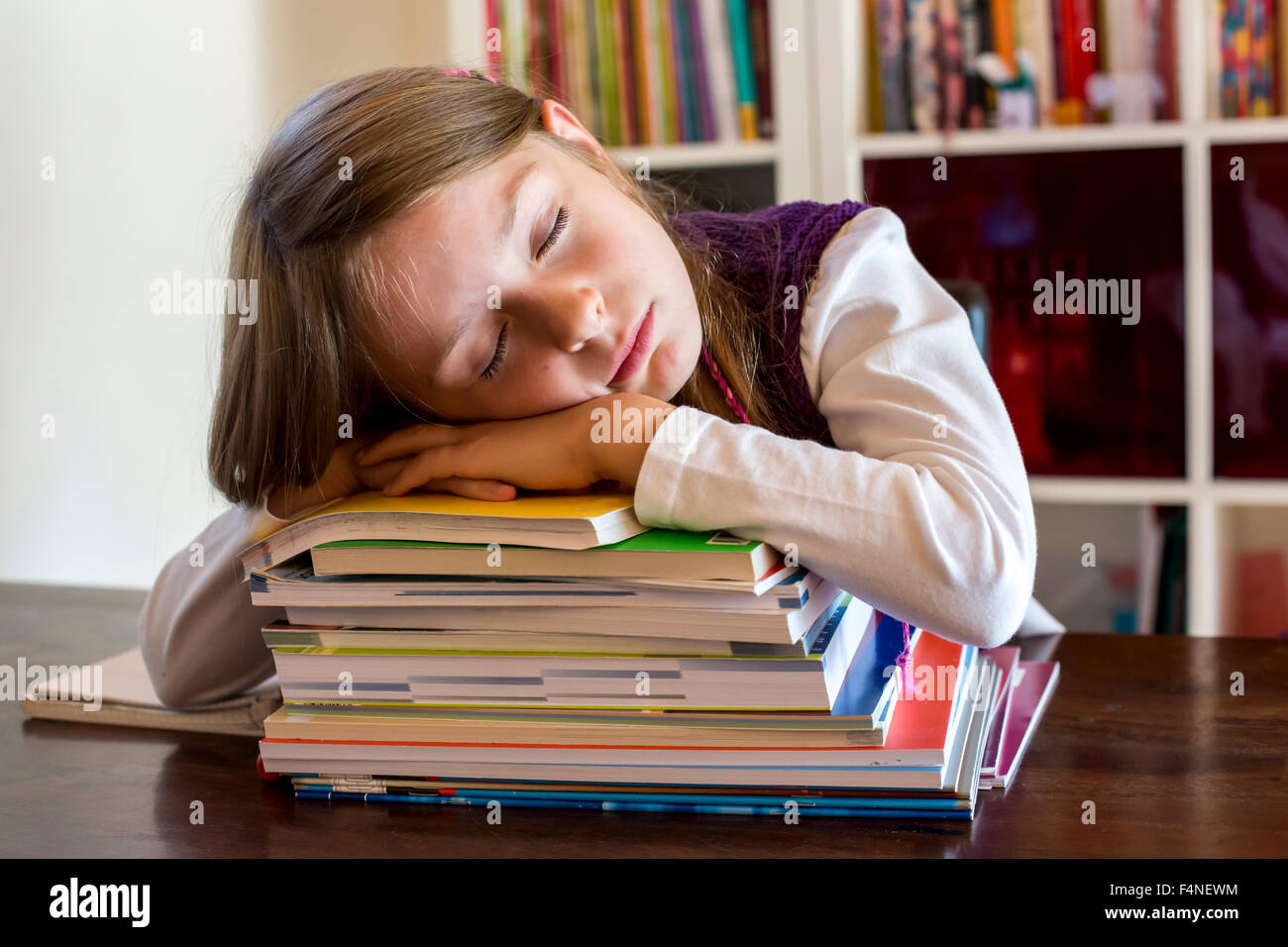 Girl sleeping on stack of school books Stock Photo - Alamy