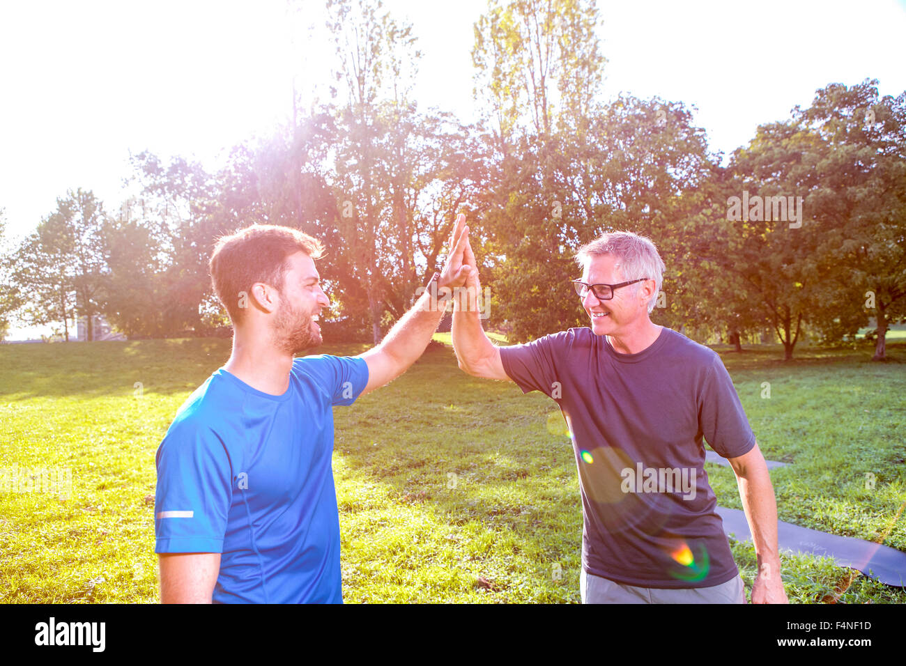 Personal trainer giving client high five after training in a park Stock ...