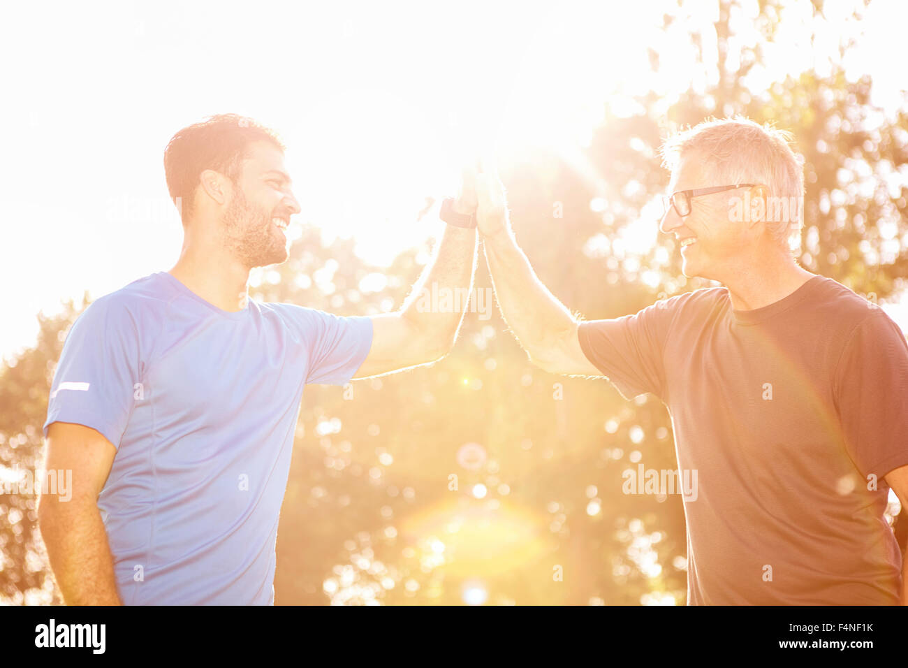 Personal trainer giving client high five after training in a park Stock ...