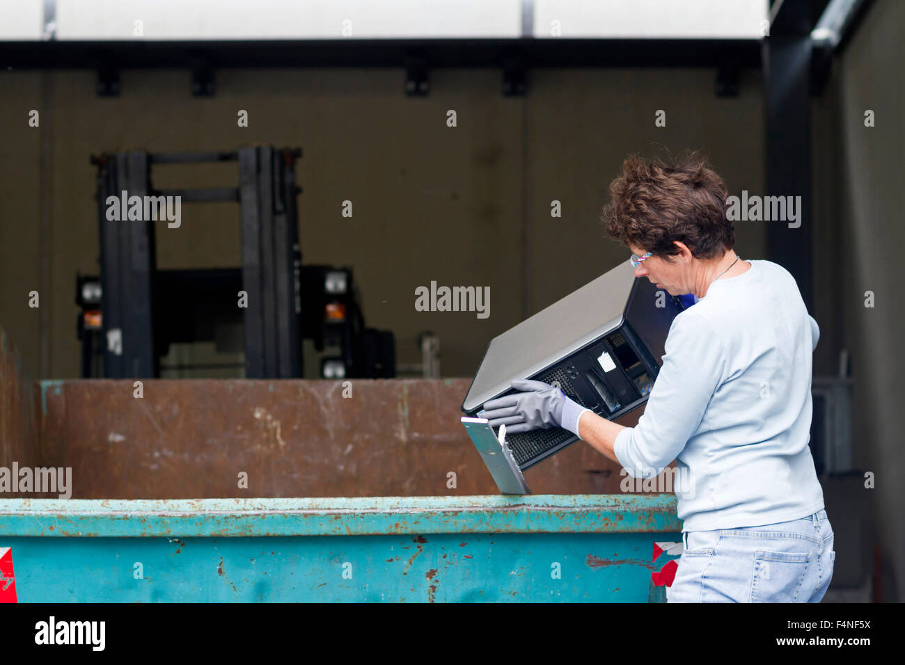 Woman at a waste container throwing away old desktop pc Stock Photo - Alamy