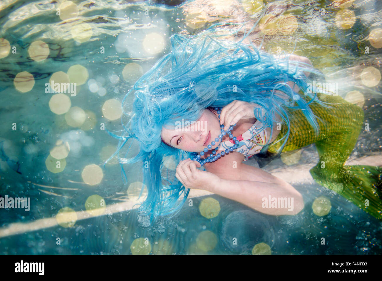 Young woman in the disguise of Arielle, the little mermaid, blue hair ...