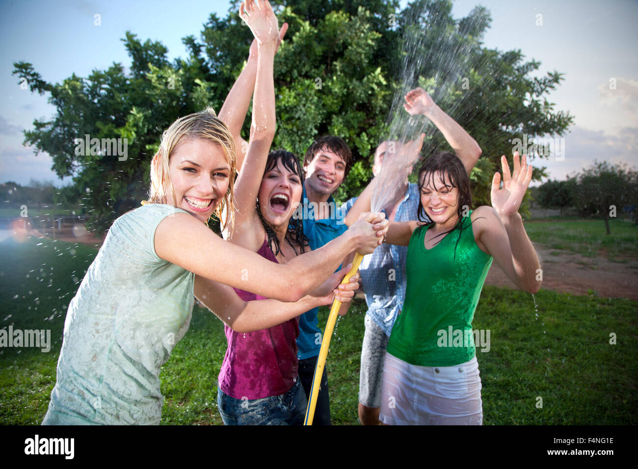 Five friends splashing water in hi-res stock photography and images - Alamy