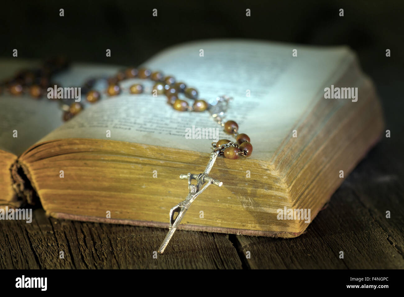 Rosary and bible on vintage wooden table by night closeup Stock Photo ...