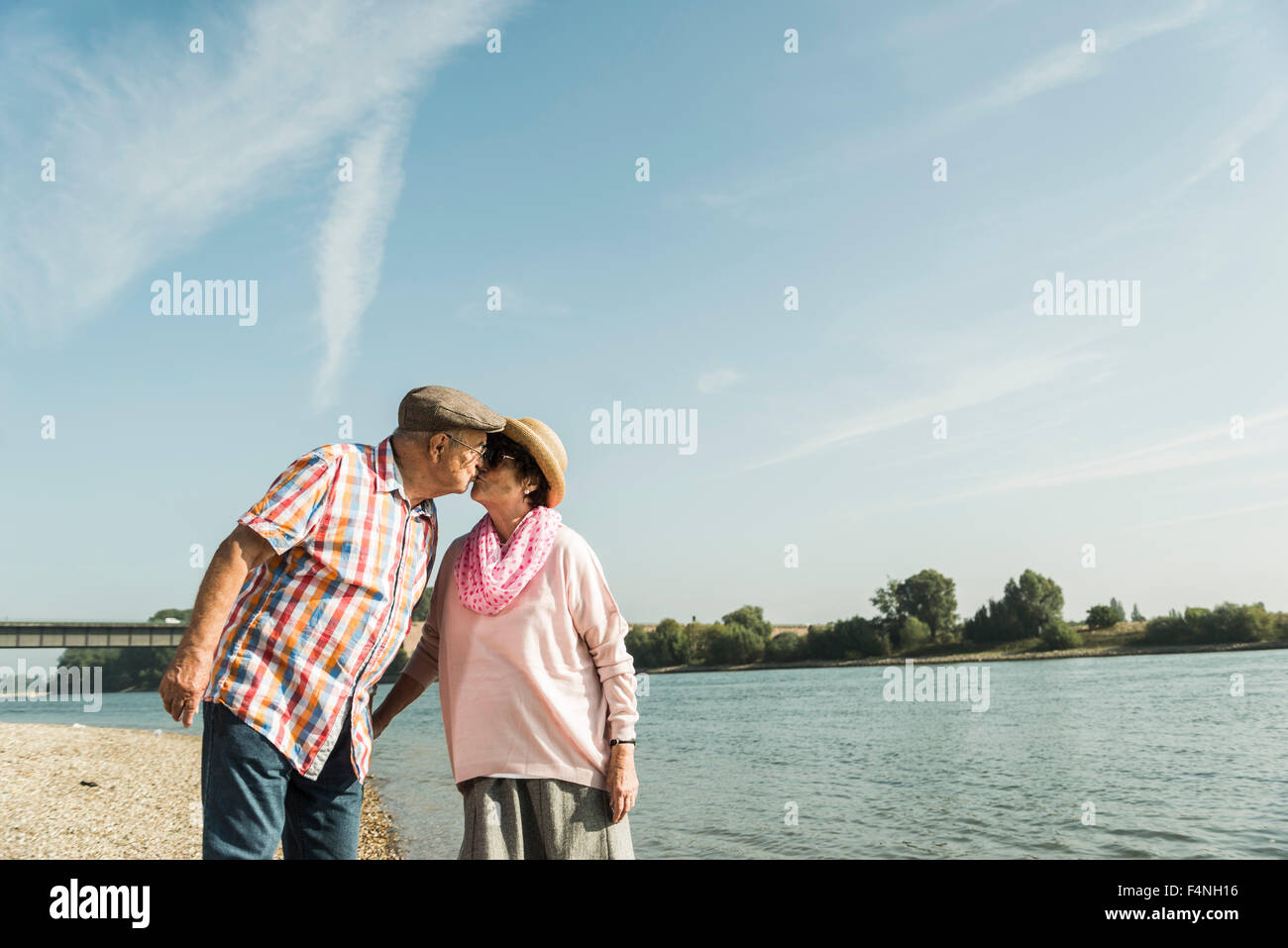 Germany, Ludwigshafen, kissing senior couple at riverside Stock Photo ...