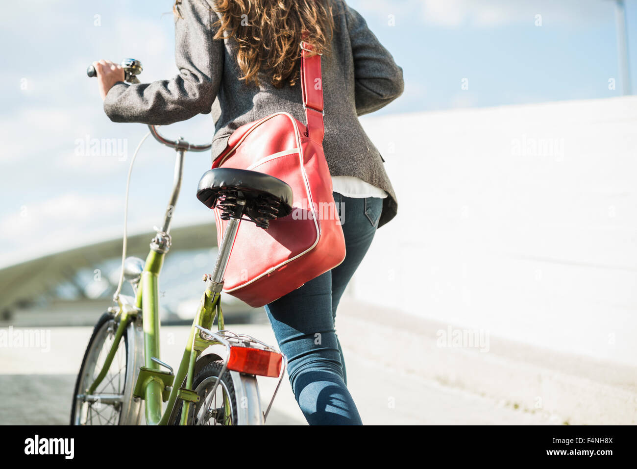 Young woman pushing bicycle Stock Photo - Alamy