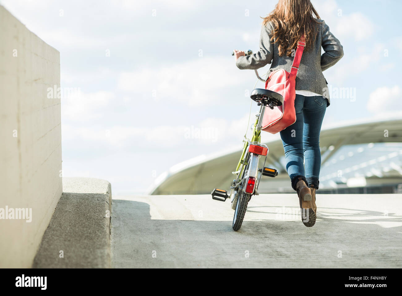 Young woman pushing bicycle Stock Photo - Alamy