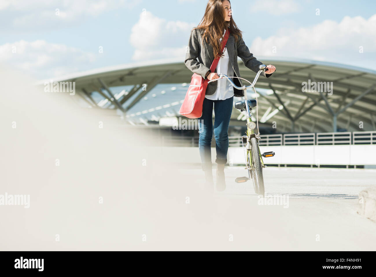 Young woman pushing bicycle Stock Photo - Alamy