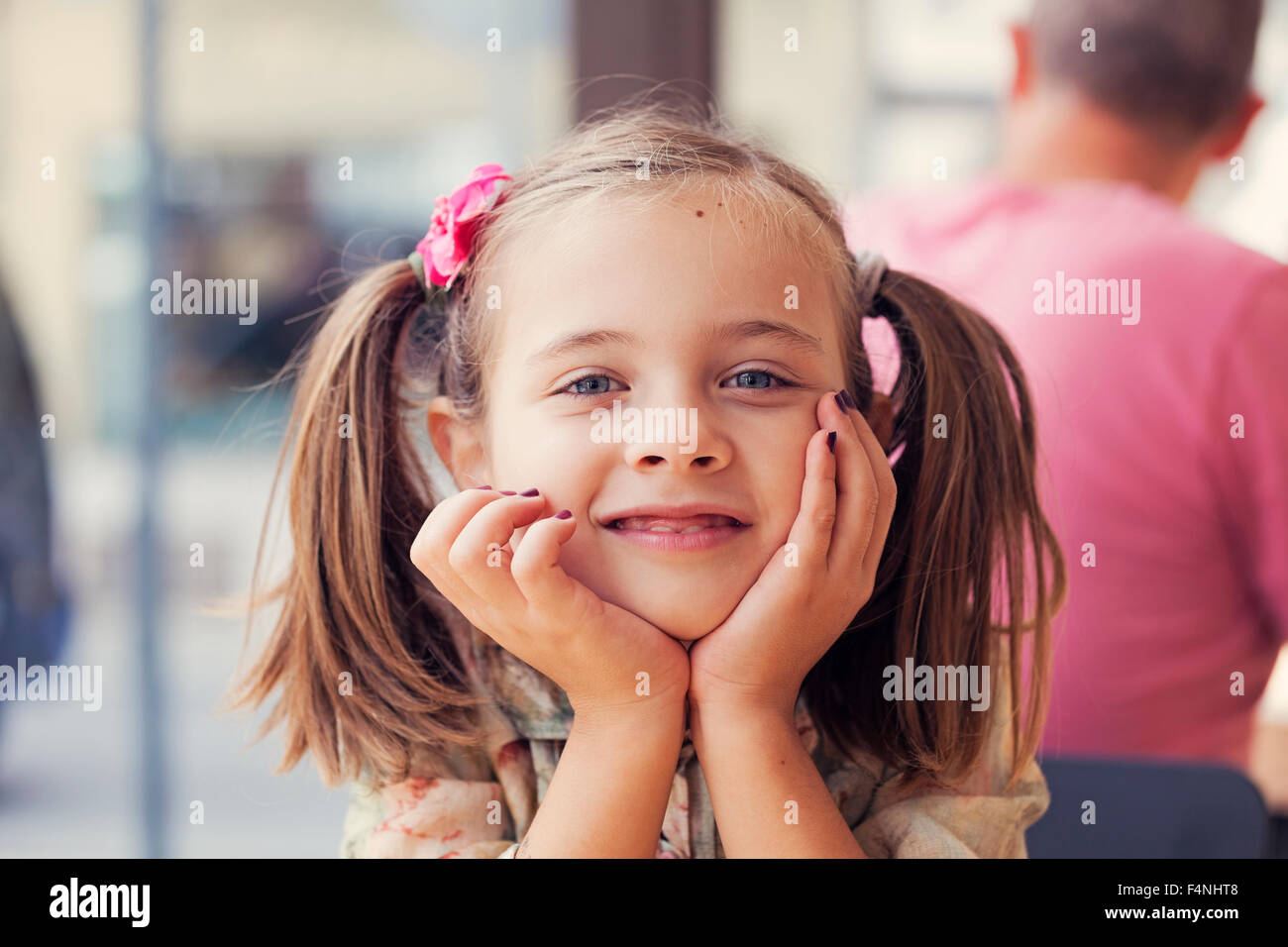 Portrait of little girl with head in her hands Stock Photo - Alamy