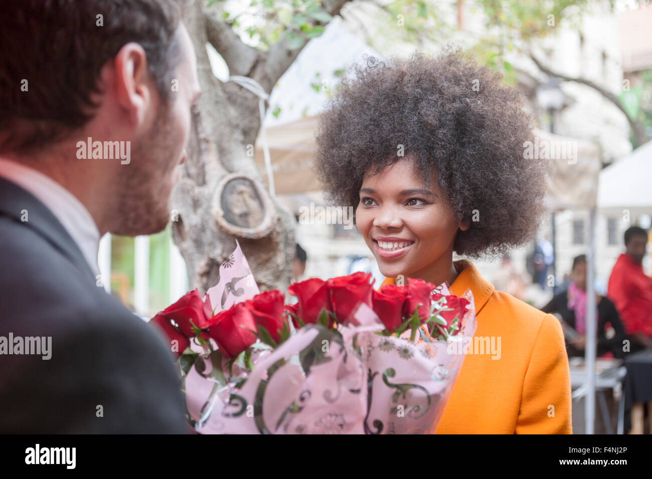 Man buying red roses for a woman Stock Photo - Alamy