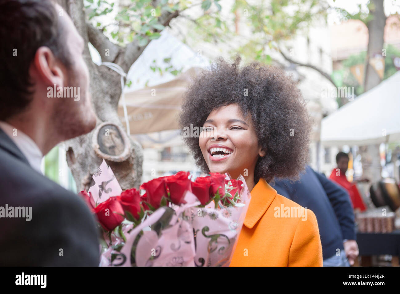 Man buying red roses for a woman Stock Photo - Alamy