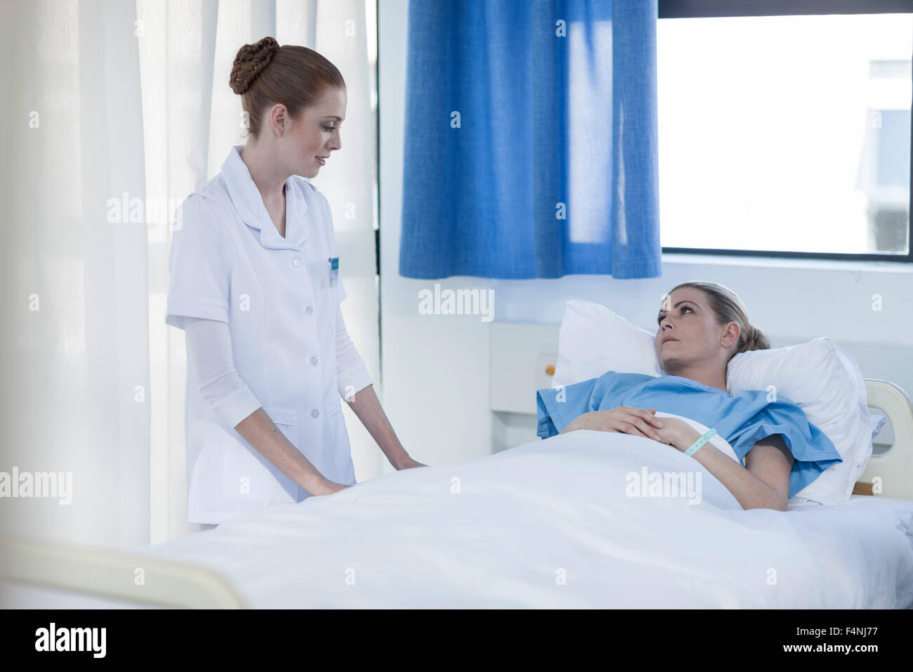 Nurse helping patient in hospital Stock Photo - Alamy