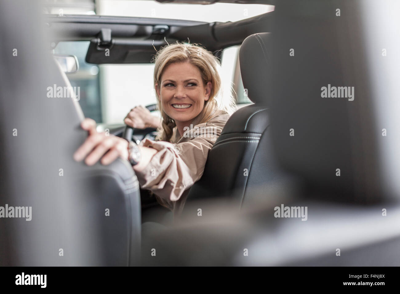 Smiling woman in car driving back out Stock Photo - Alamy