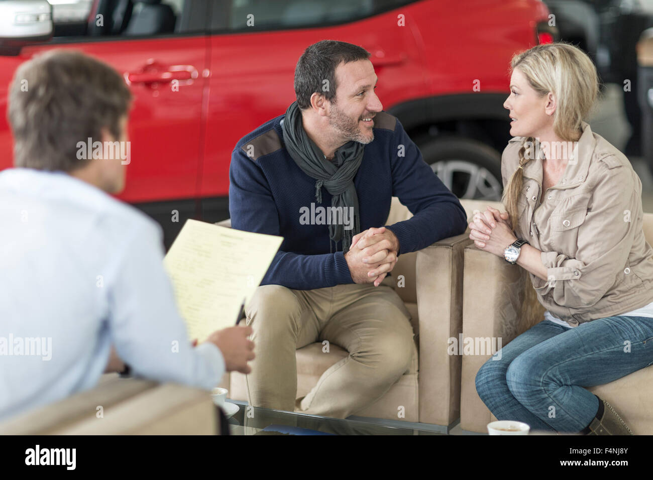 Couple discussing at car dealership Stock Photo - Alamy