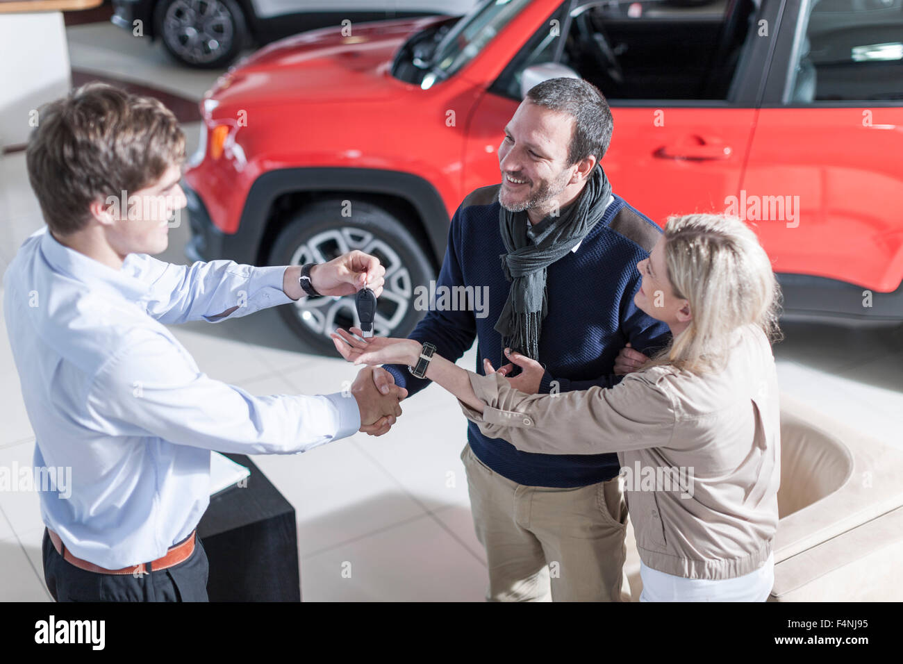 Car dealer giving key to client Stock Photo - Alamy