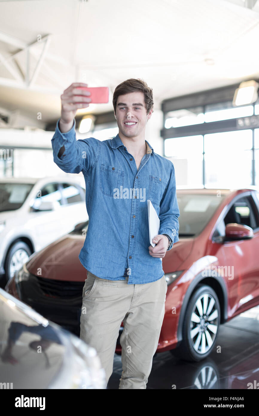 Man at car dealership taking a selfie Stock Photo - Alamy