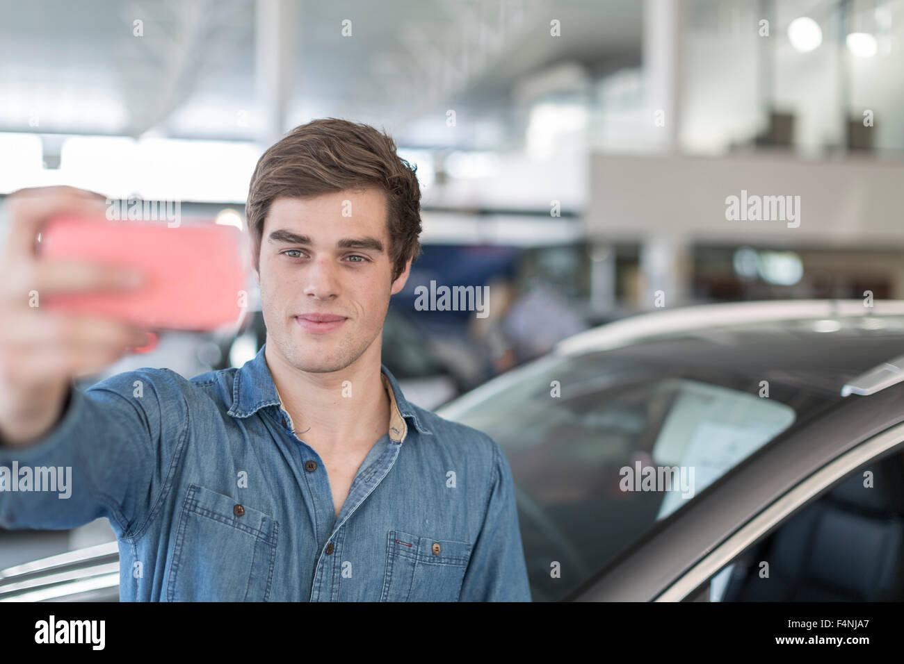 Man at car dealership taking a selfie Stock Photo - Alamy