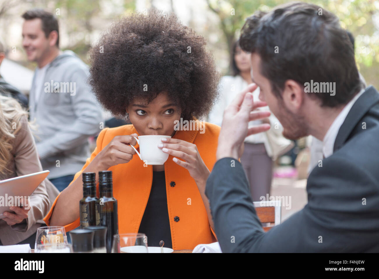 Two colleagues talking at outdoor cafe Stock Photo - Alamy