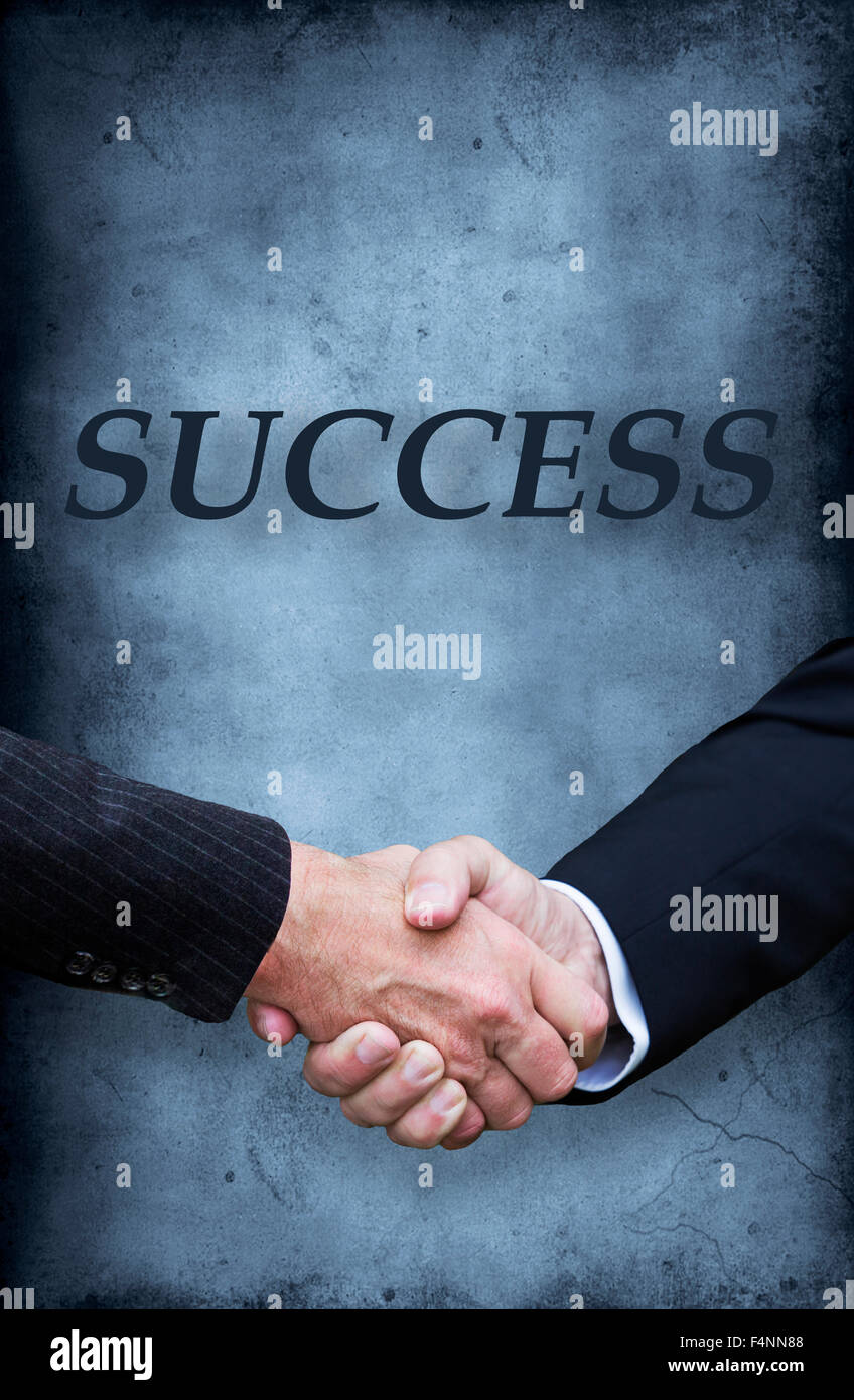 handshake of businessmen and the word success written in the background ...