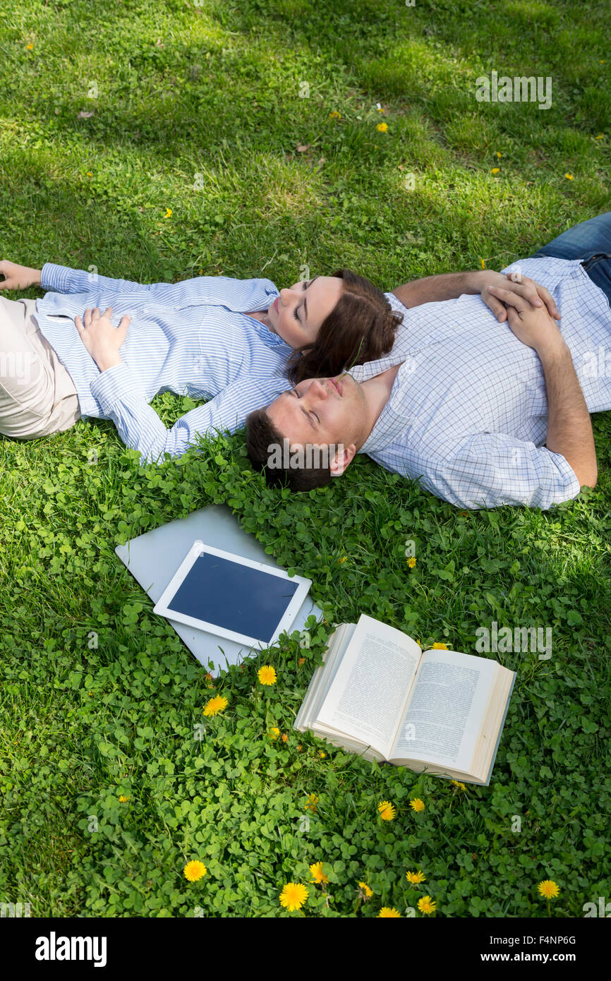 Two people napping on grassy lawn Stock Photo - Alamy