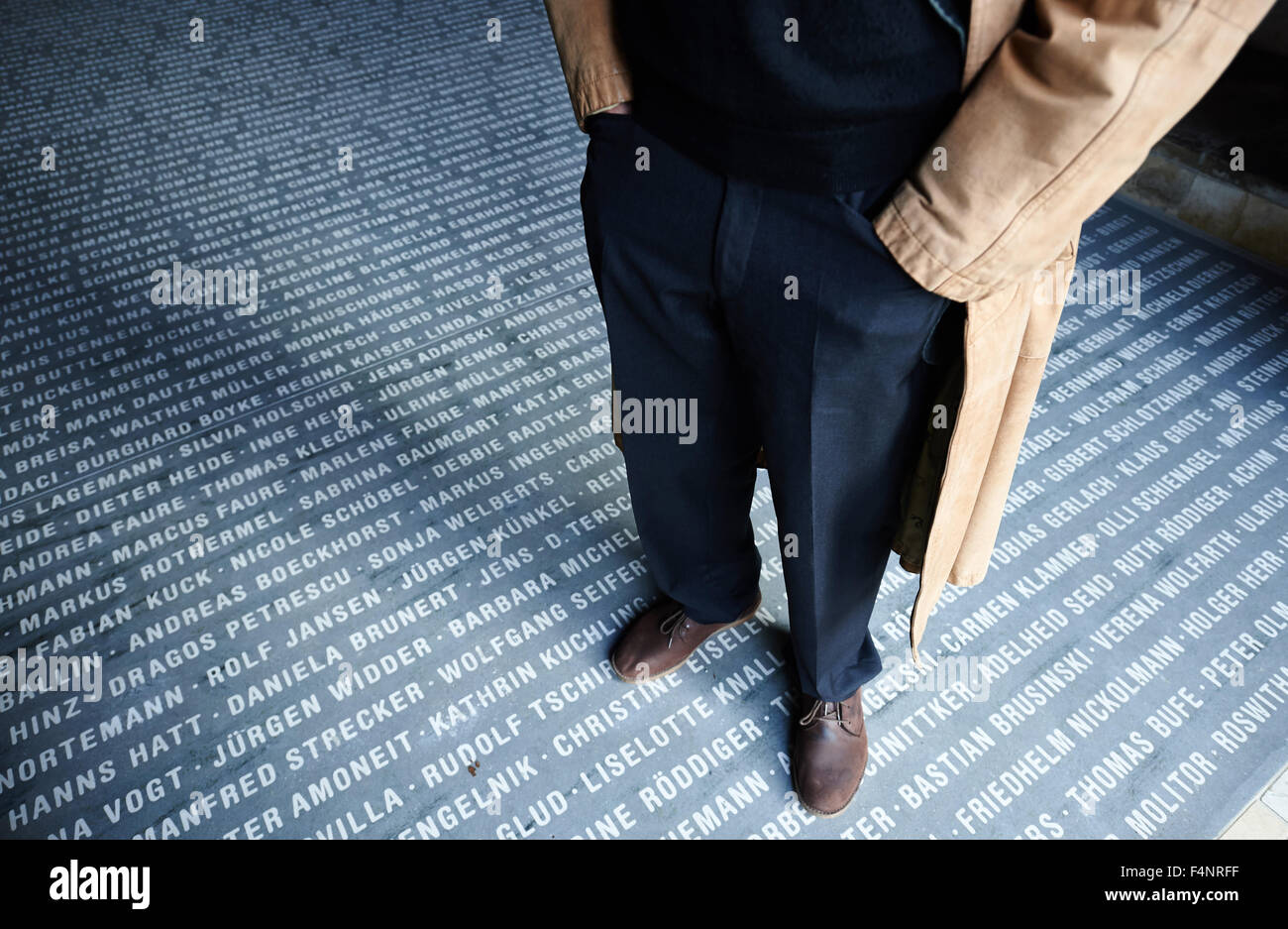 Conceptual artist Jochen Gerz stands on a flagstone engraved with the ...