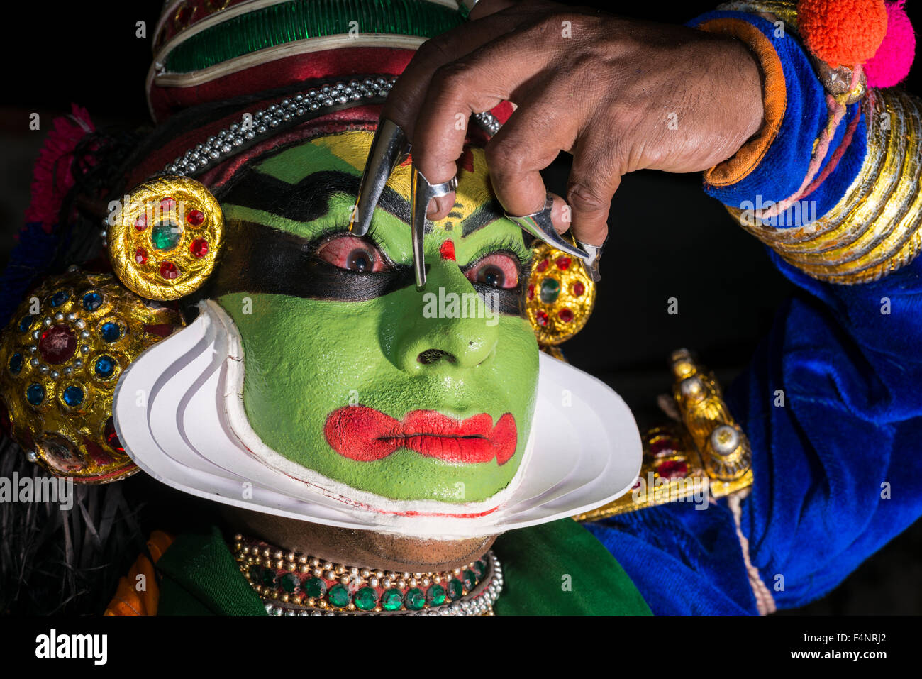 A Katakali artist is posing with the complete make up of the character ...