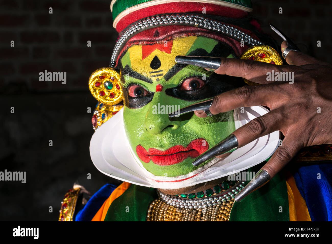 A Katakali artist is posing with the complete make up of the character ...