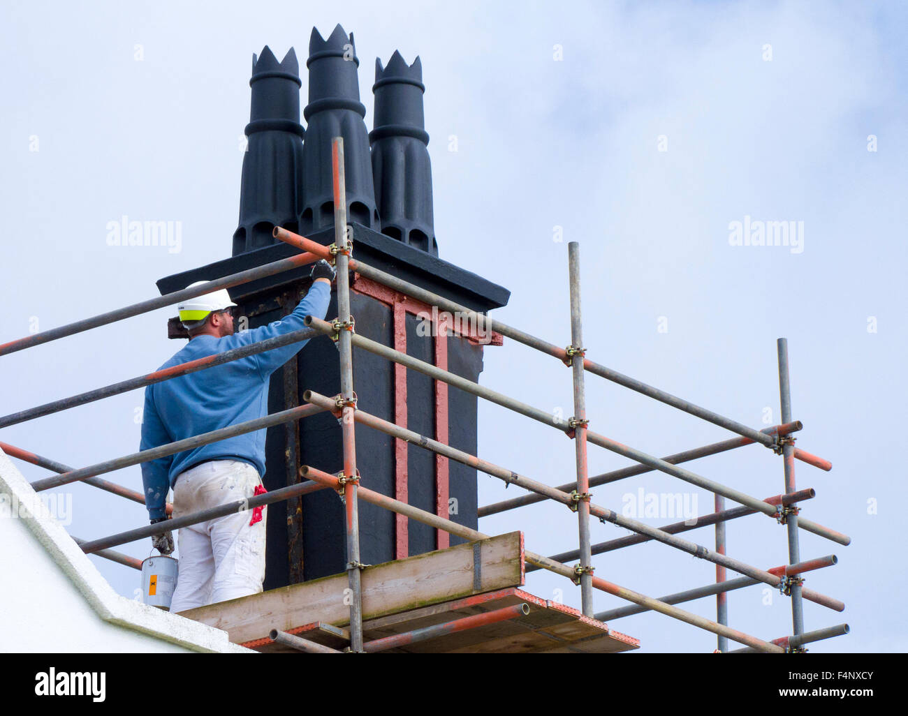Painter and Decorator Painting a Chimney Stack Whilst on Scaffolding ...