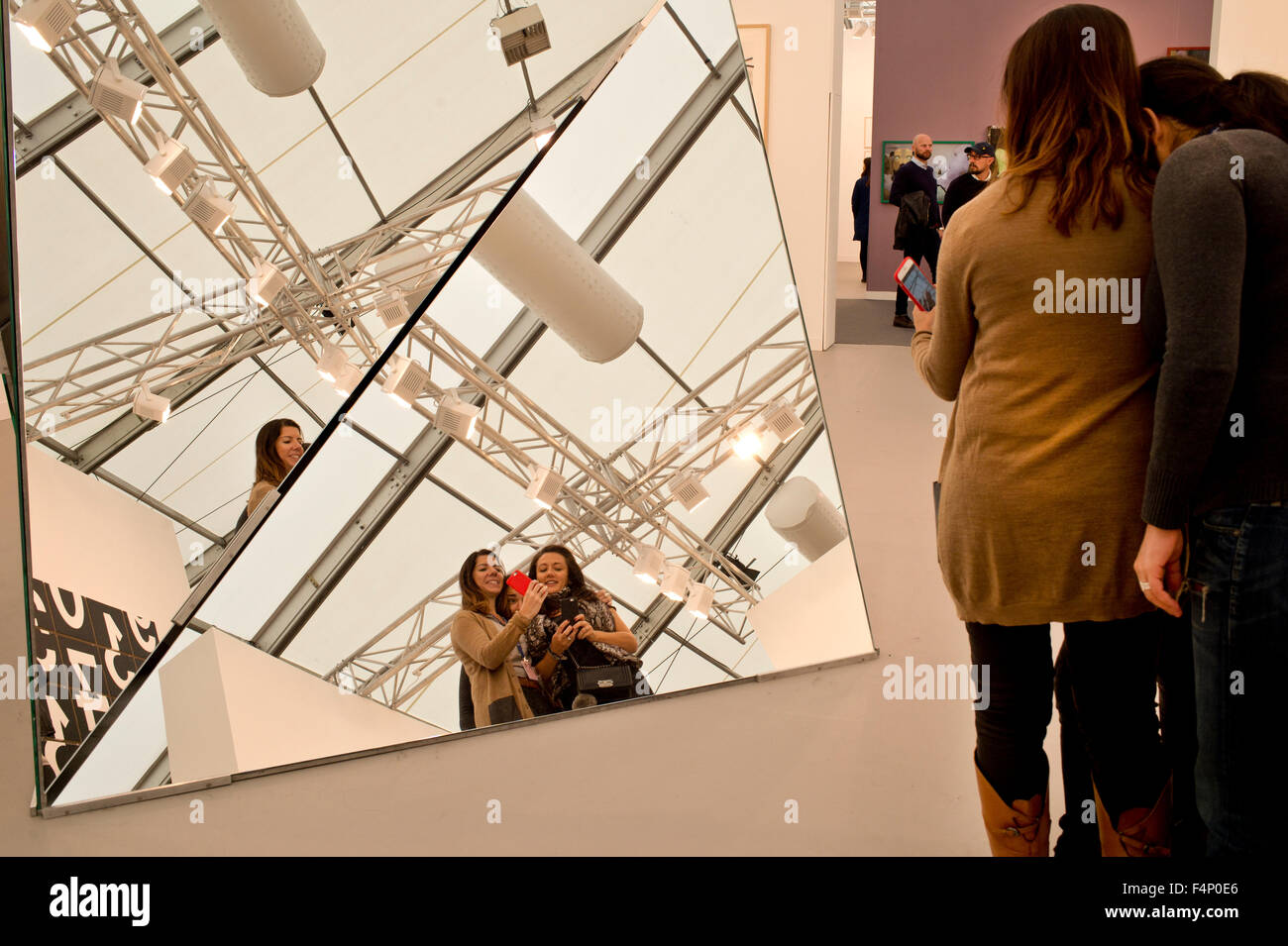 Frieze Art Fair London. 2015. Visitors reflected in fragmented mirror ...