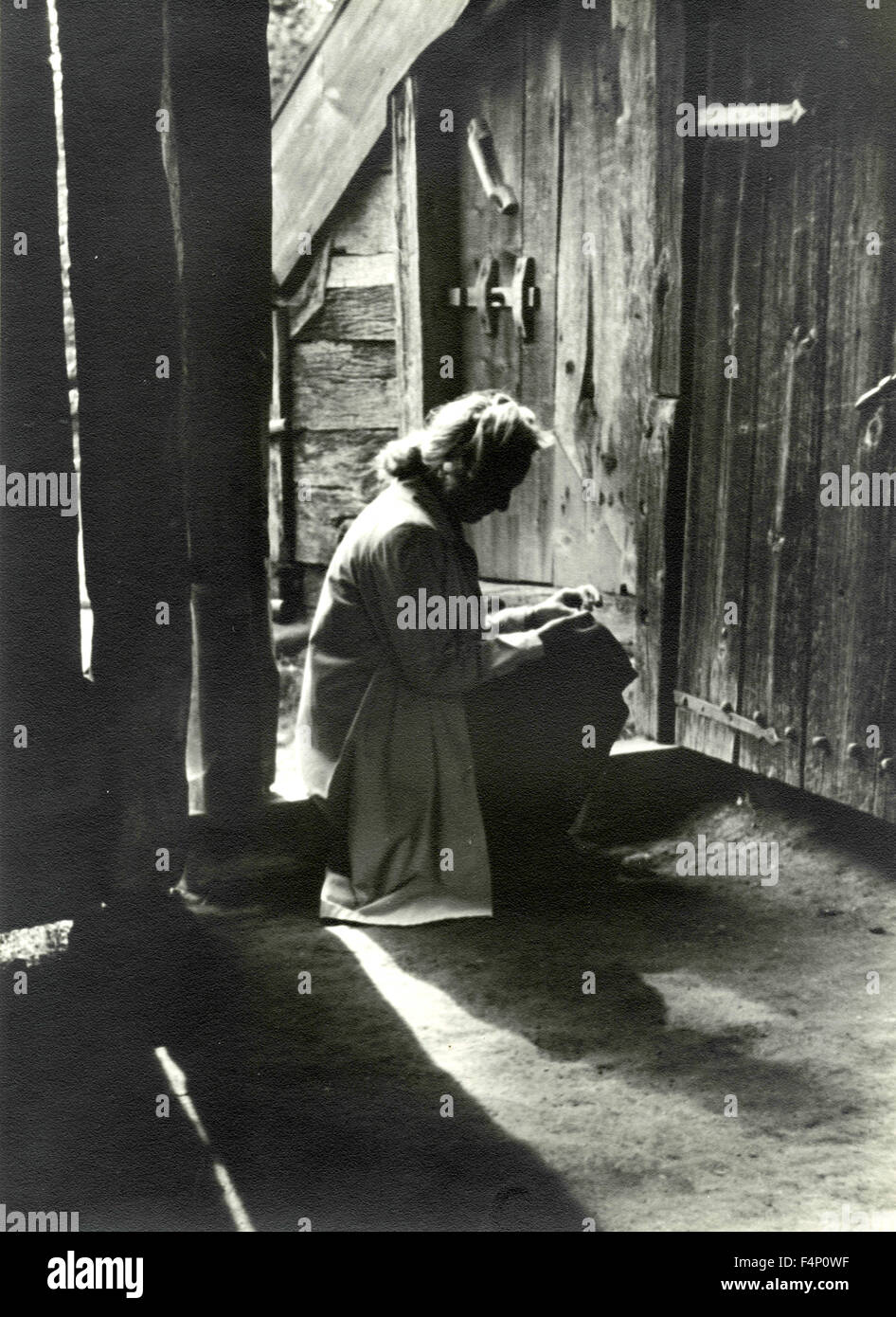 Woman sitting on the threshold of a door Stock Photo - Alamy