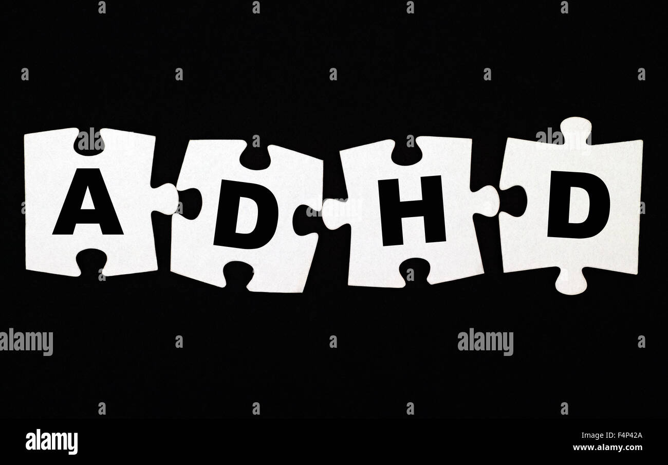Four pieces of puzzle with letters ADHD on black background. ADHD is ...