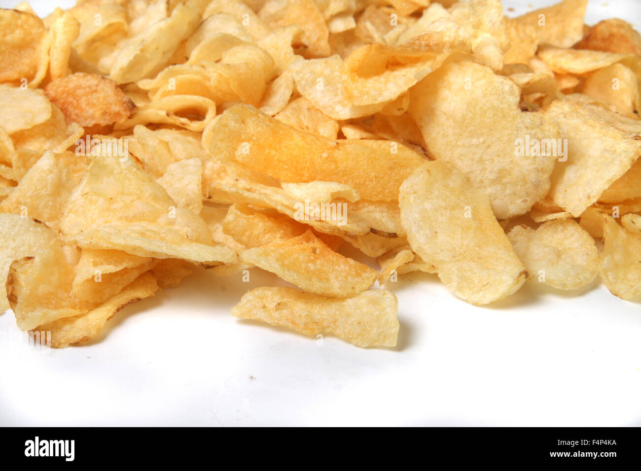 kettle chips spilling over on a white background Stock Photo - Alamy