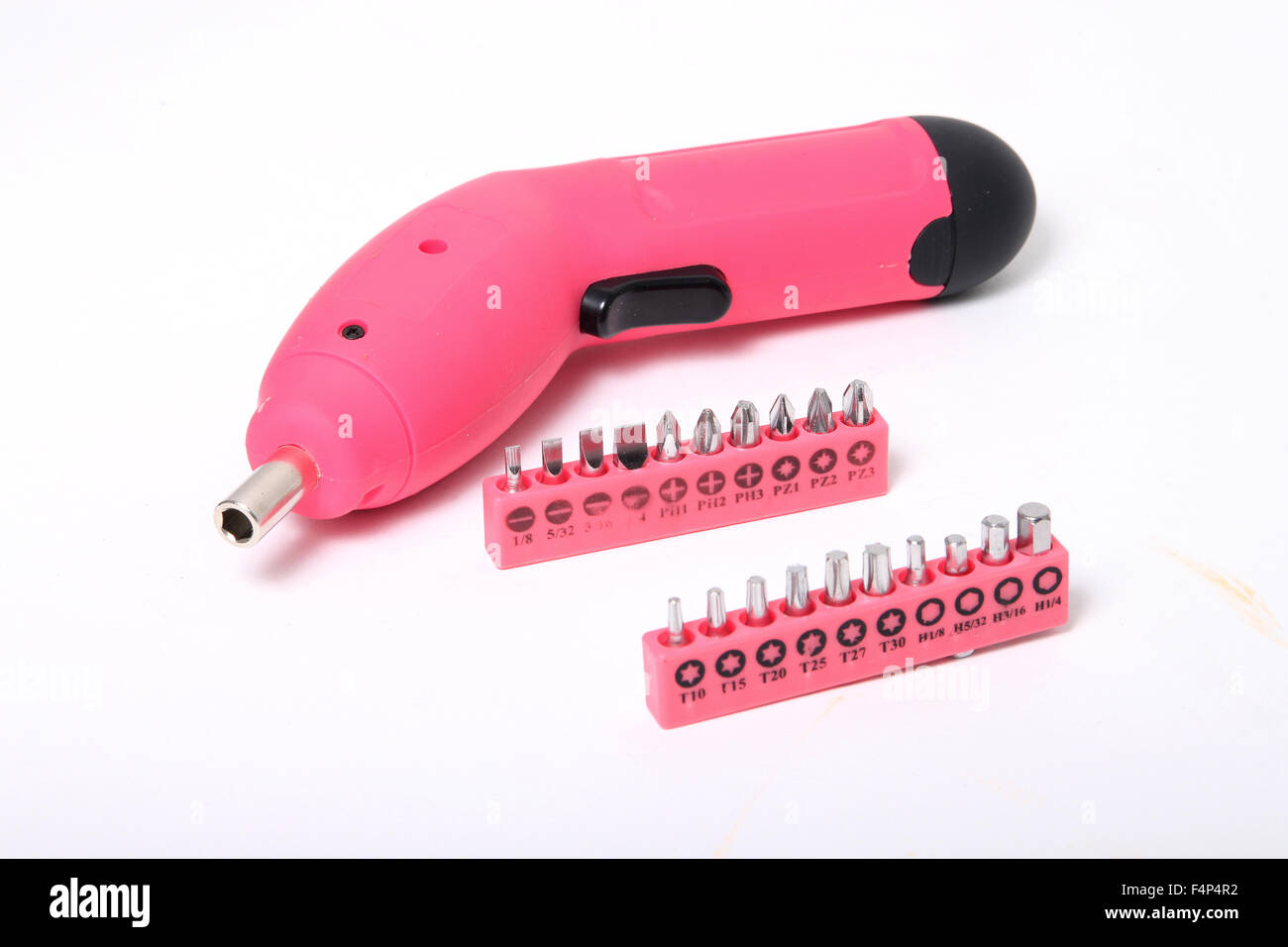 Pink cordless screwdriver and bits in different sizes on a white ...