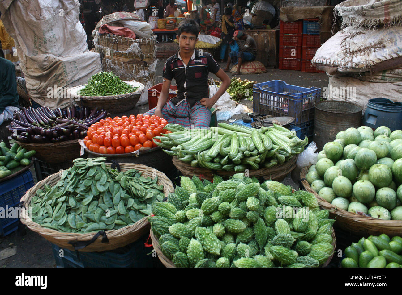 Bangladeshi vegetable vendors wait for customer at Karwan Bazar kitchen market in Dhaka ...