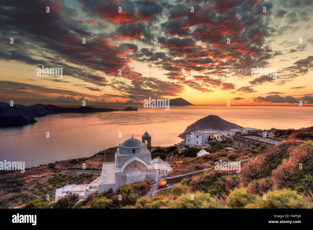 The sunset from the castle above the village of Plaka in Milos, Greece. Below the church of The ...