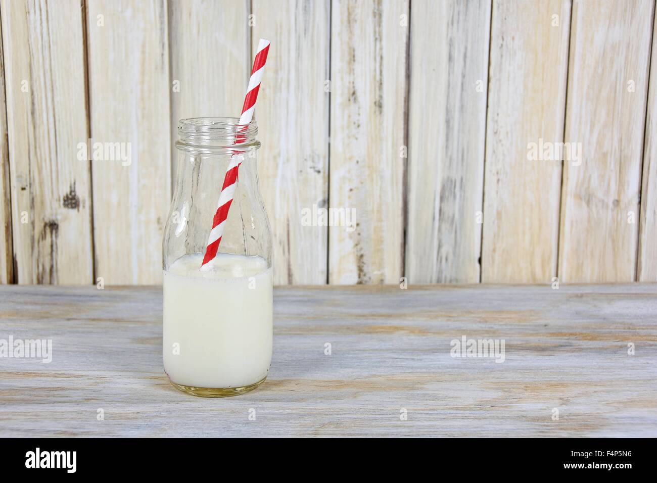 White milk and red and white striped straw in retro milk bottle on ...