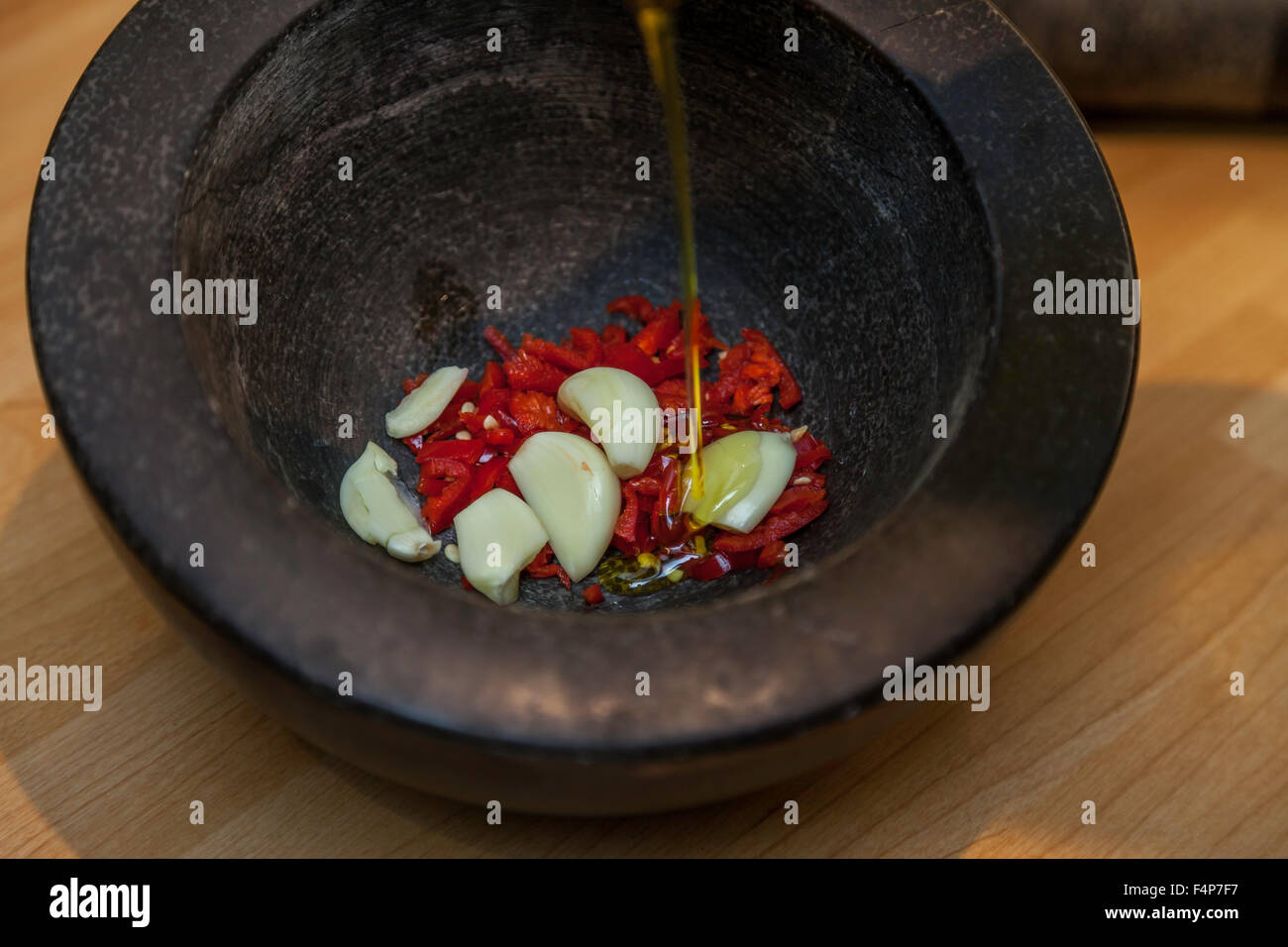Pestle and mortar, with chili, garlic and oil Stock Photo - Alamy
