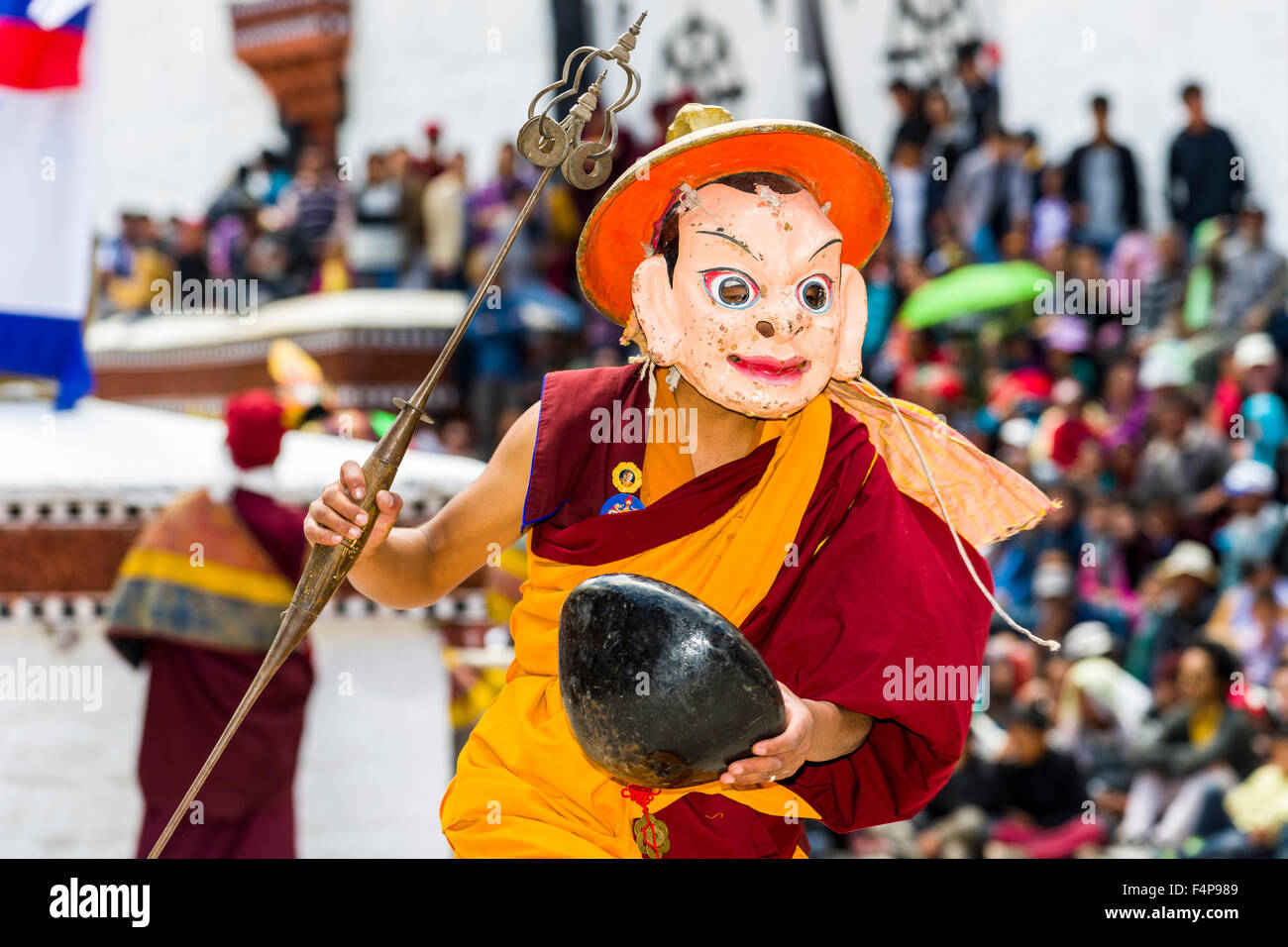 Monks with big wooden masks and colorful costumes are performing ritual ...