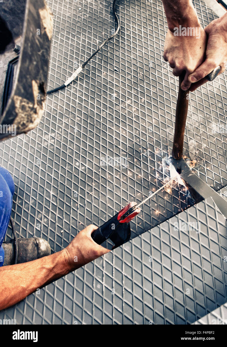 Two men working over iron platform with arc welding Stock Photo - Alamy