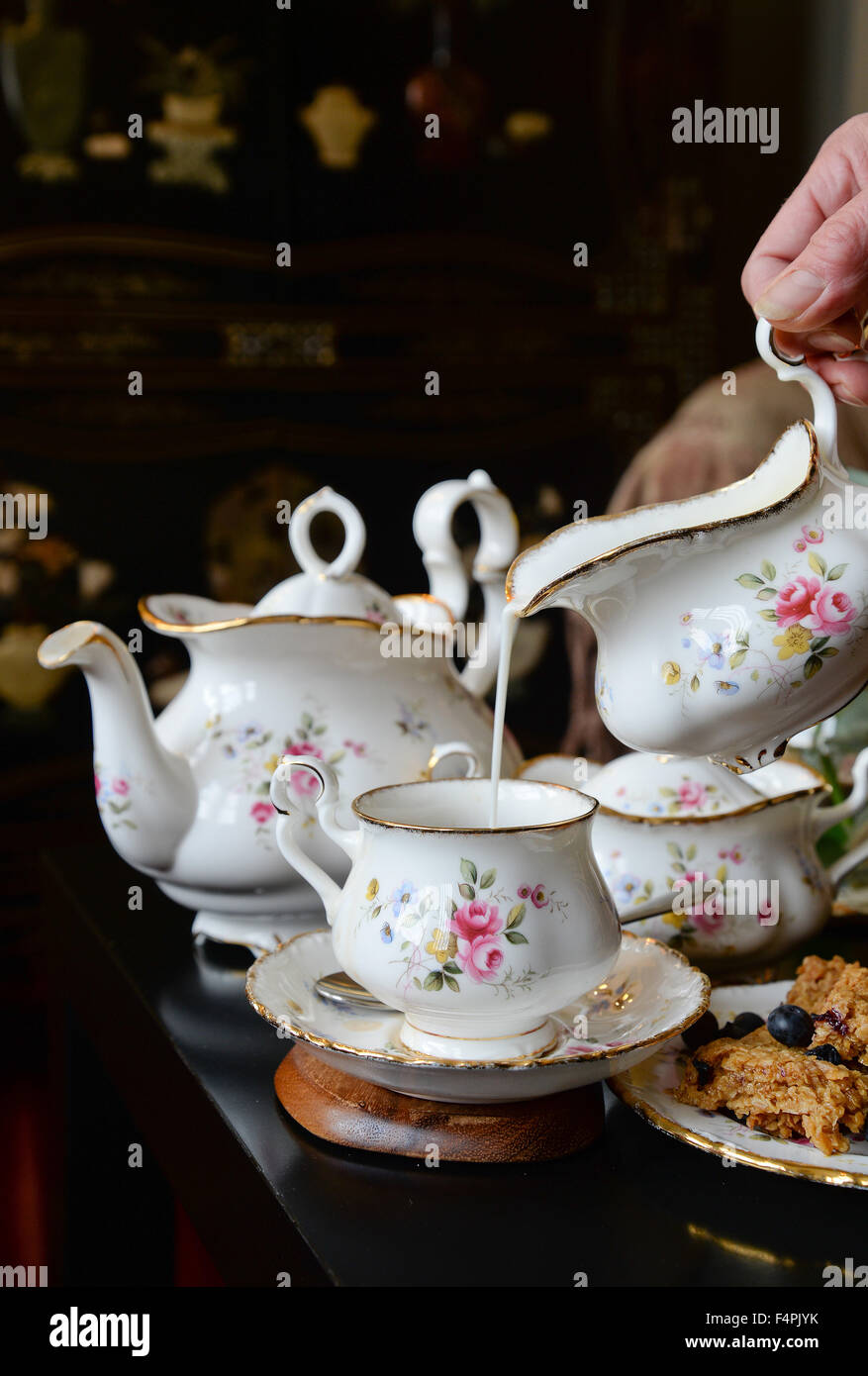 Taking afternoon tea, pouring the milk Stock Photo - Alamy