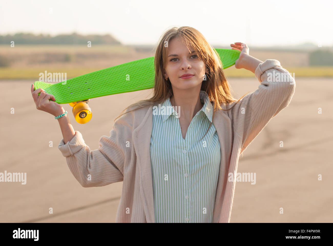 Pretty girl standing with a skateboard in the street Stock Photo - Alamy