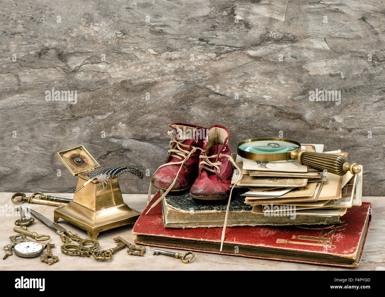 Antique books and photos, keys and writing accessories. Nostalgic still life with old baby shoes ...
