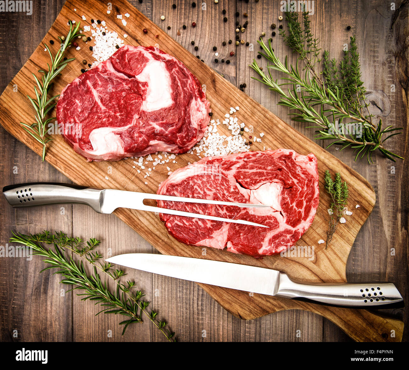 Raw fresh beef meat with herbs and spices on wooden background. Retro ...