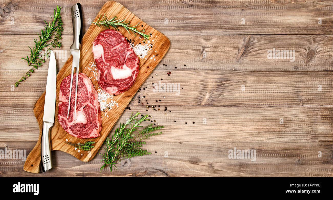 Raw beef steack meat with herbs and spices on wooden kitchen desk. Food ...