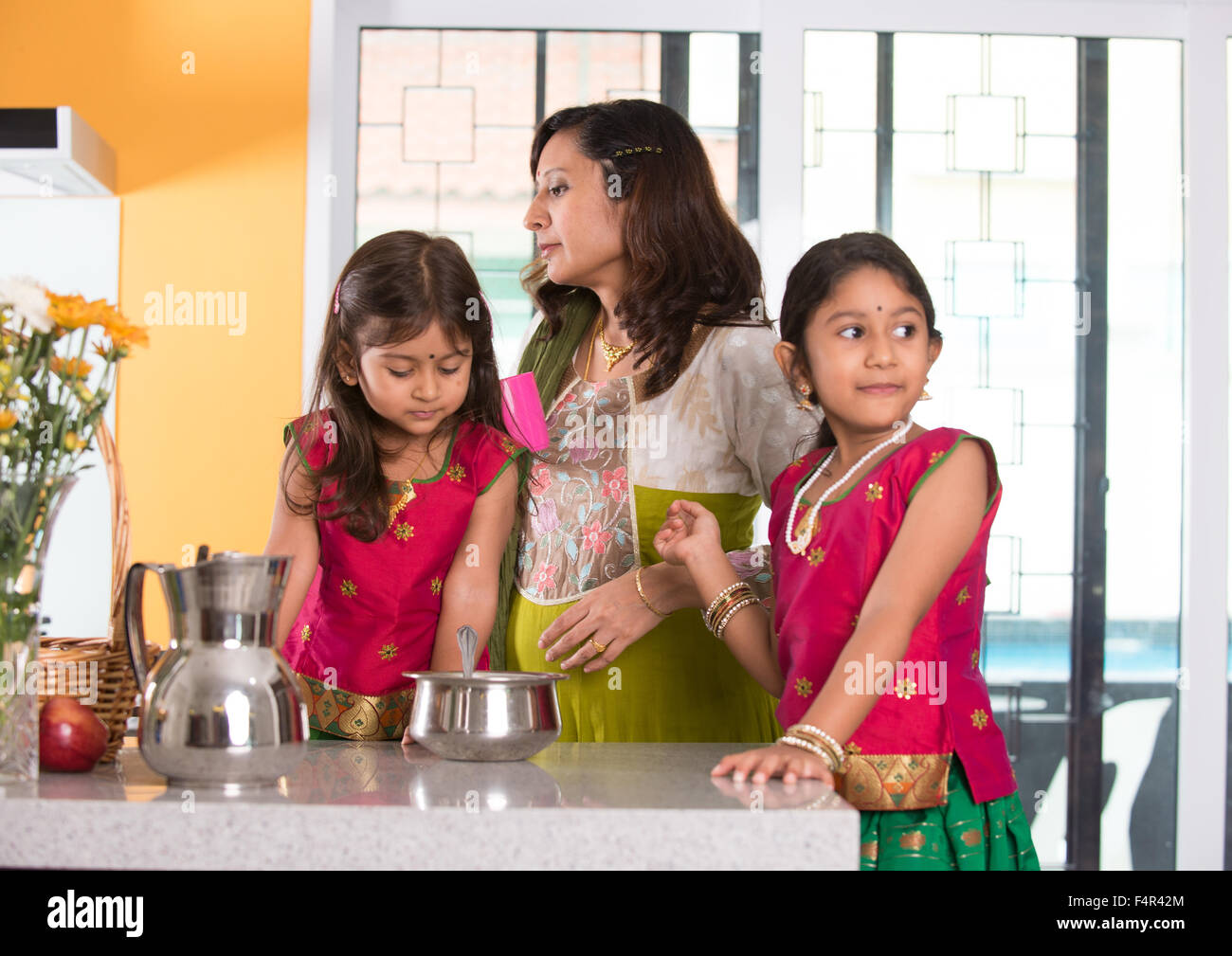indian mother cooking with her daughters at kitchen Stock Photo - Alamy