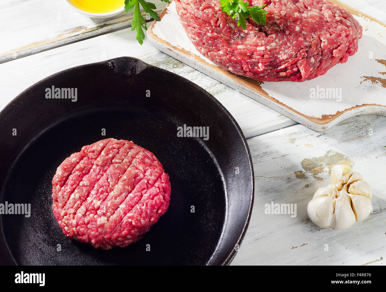 Raw beef burger patty on a iron pan. Selective focus Stock Photo - Alamy