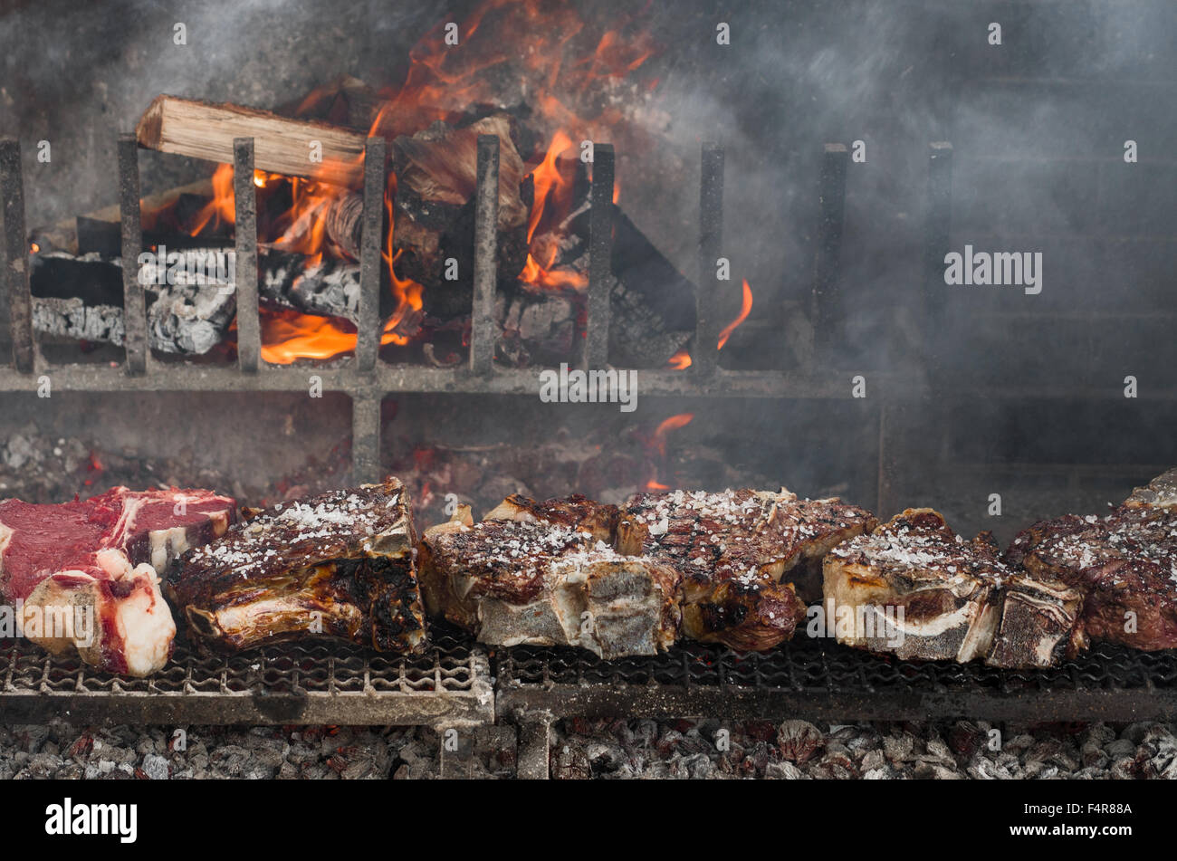 Thick slices of meat from chianina cow grilling over the embers Stock ...