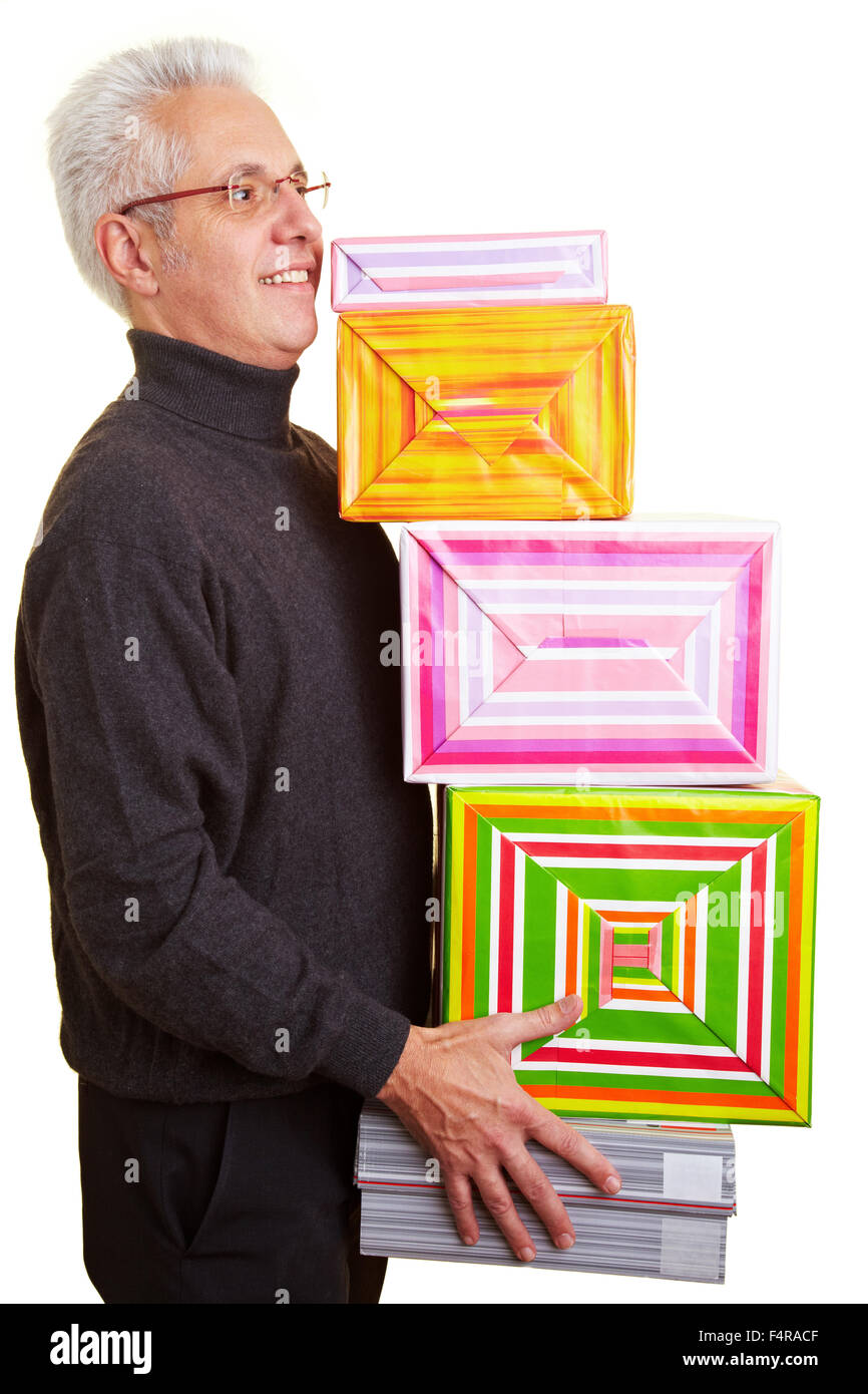 Senior citizen carrying a stack of presents Stock Photo - Alamy