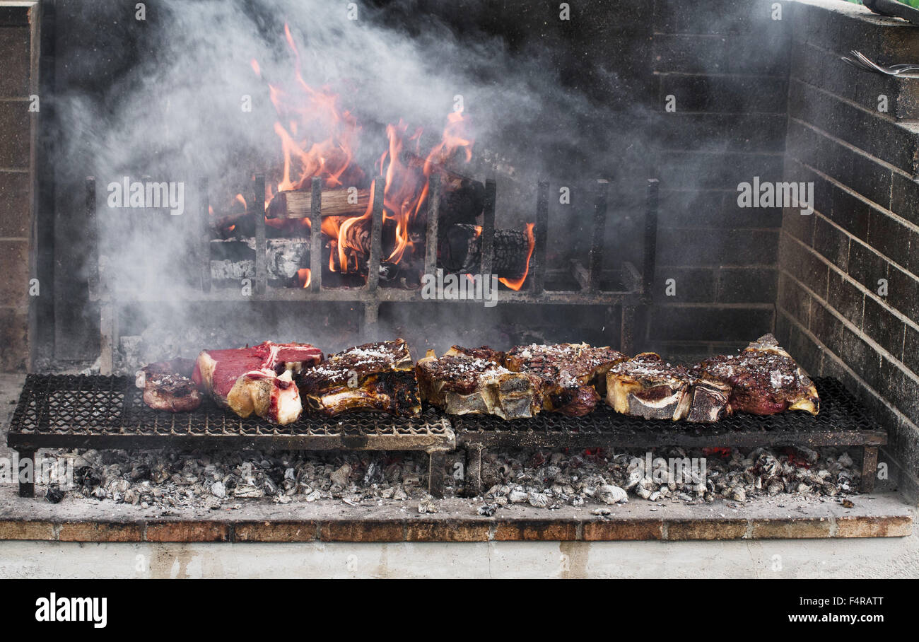 Thick slices of meat from chianina cow grilling over the embers Stock ...